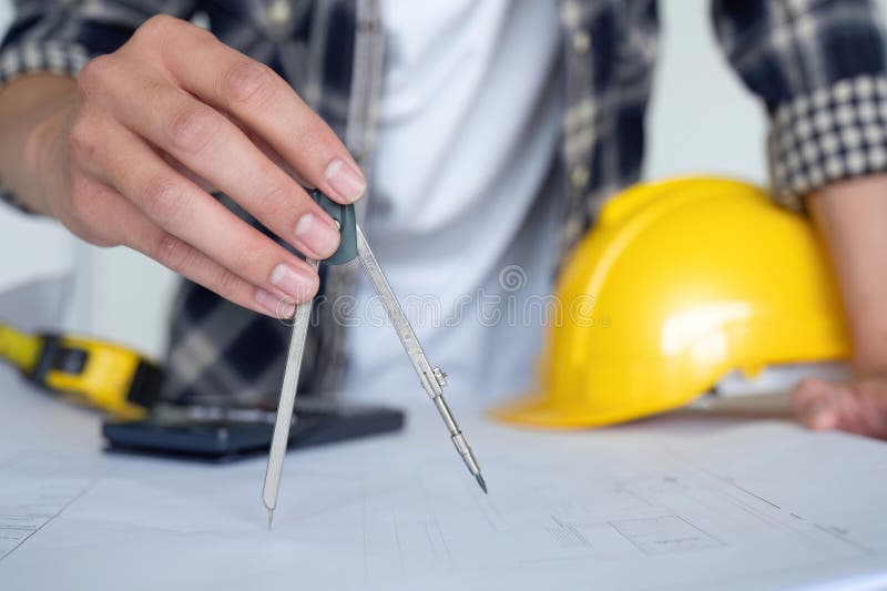 Young Asian Engineer Drawing Construction Project Plans on Plan Paper ...