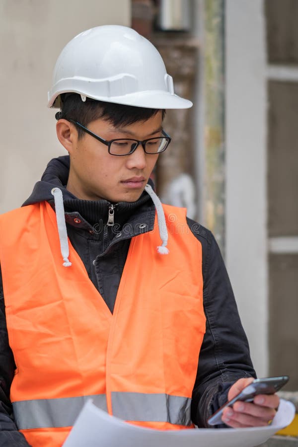 Young Asian Engineer Using His Smartphone on Construction Site Stock ...
