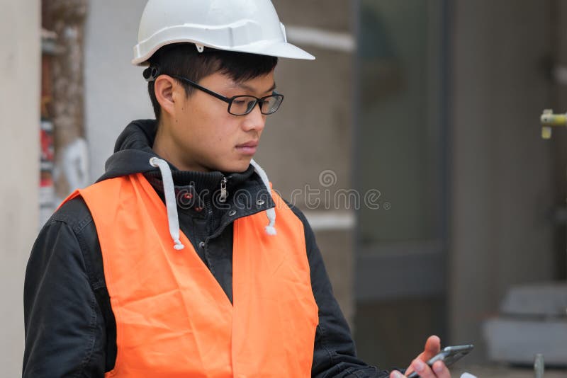 Young Asian Engineer Using His Smartphone on Construction Site Stock ...