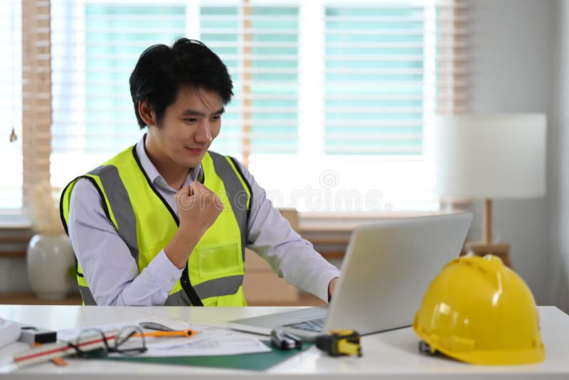 Young Engineer Worker in Reflective Jacket Looking at Laptop Computer ...