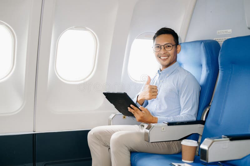 Young Asian Executive Excels in First Class, Multitasking with Digital ...