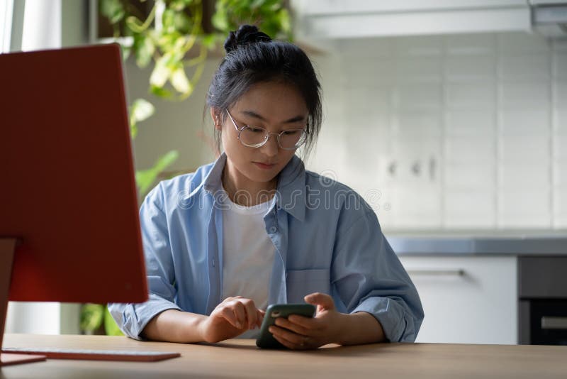 Young Asian Female Freelancer Scrolling Her Phone, Getting Distracted ...