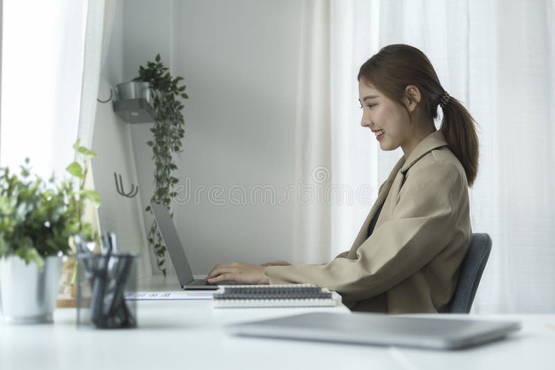 Young Asian Female Office Worker Sitting in Bright Office and Working ...
