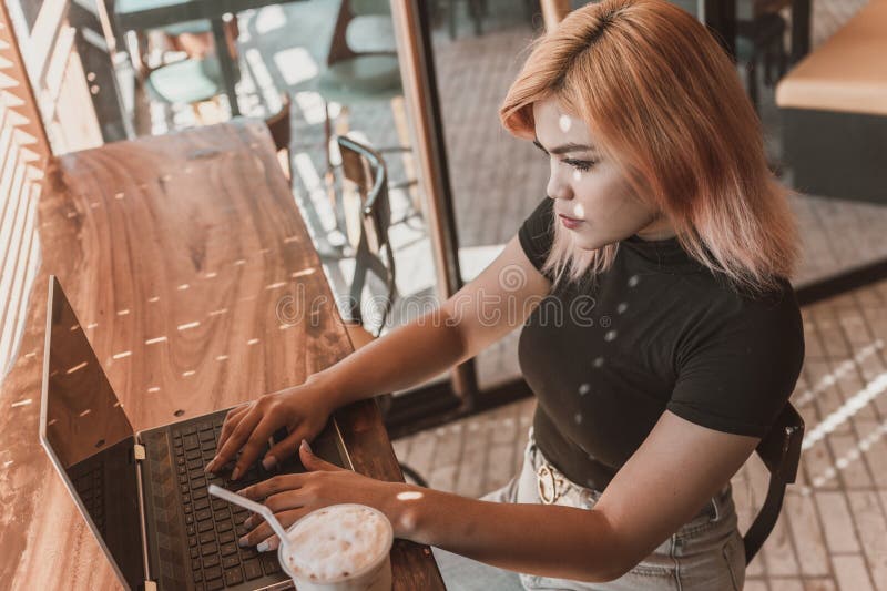 A Young Asian Freelance Virtual Assistant Working Remotely at an ...