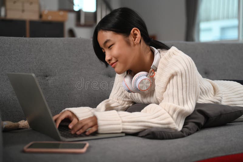 Young Girl Lying on Sofa and Using Laptop Computer. Stock Image - Image ...