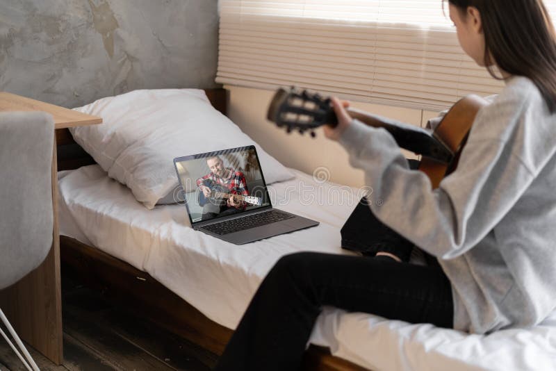 Young Asian Girl Playing Guitar Sitting on Bed Watching Video Tutorial ...