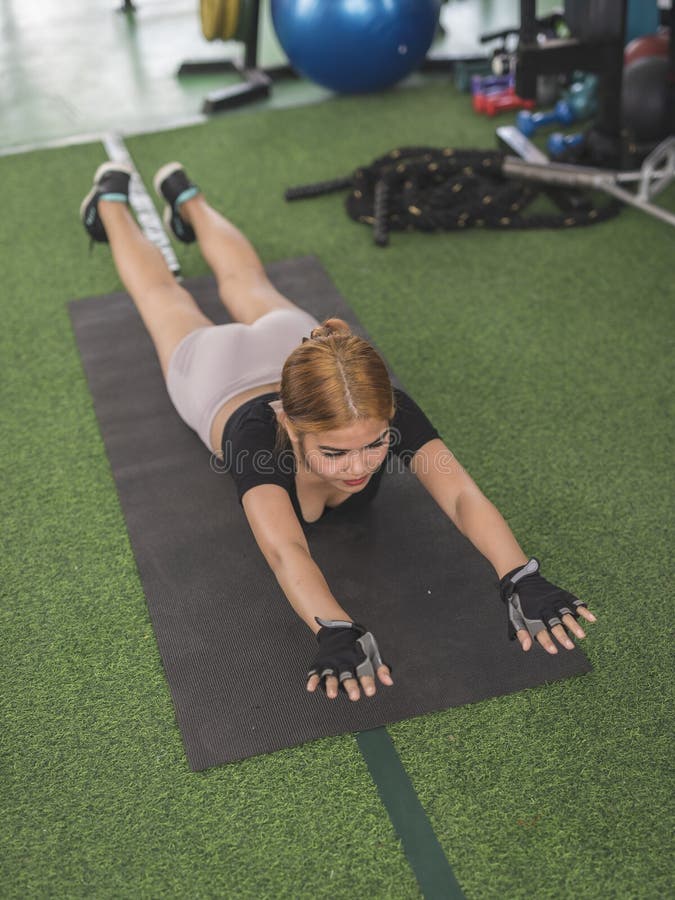 A Young Asian Lady Does Superman Back Extensions on a Black Mat ...