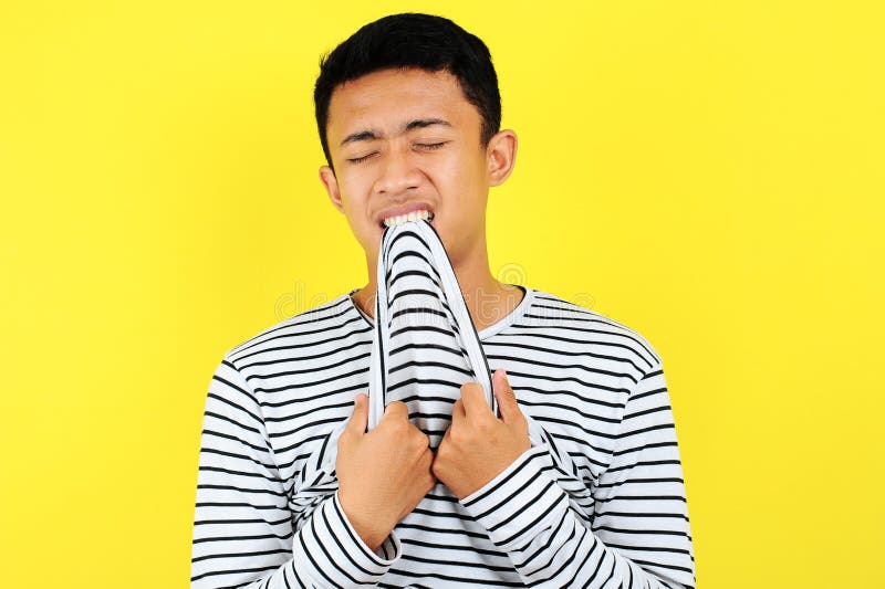 Young Asian Man Biting Clothes, on Yellow Stock Image - Image of ...