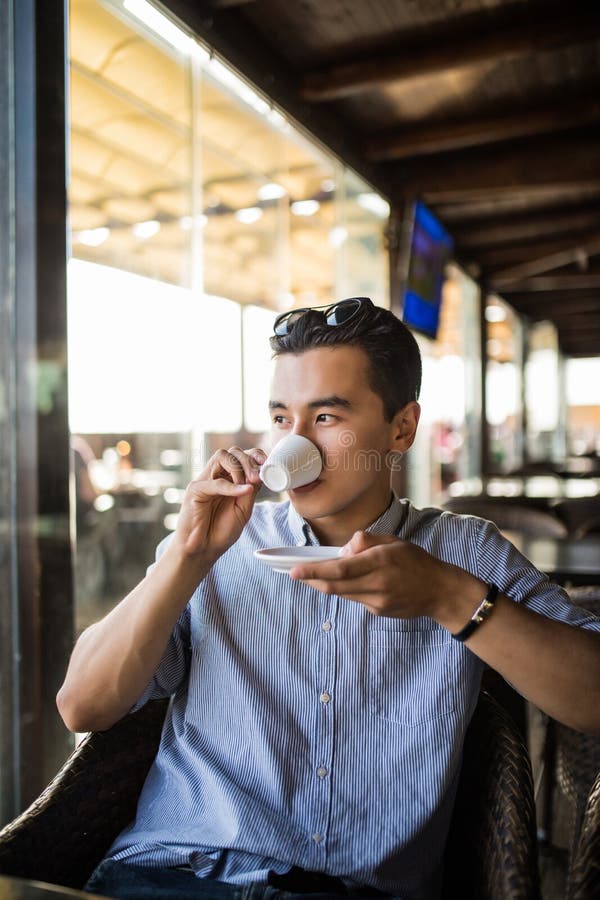 Young Asian Man is Drinking Coffee in Cafe. Freelance Work Stock Image ...