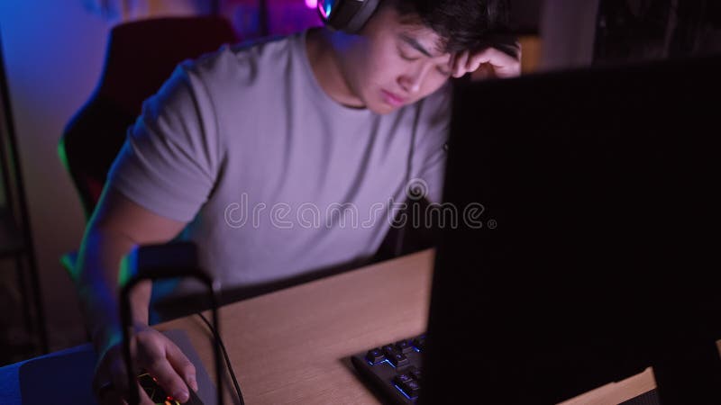 Young Asian Man Gaming at Night in a Dark Room, Focused and Using a ...