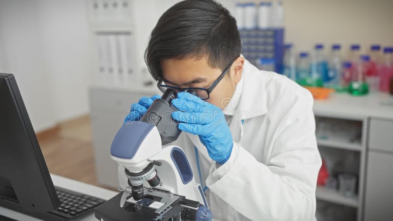 Man in a Lab Coat Using a Microscope To Examine a Sample, Suitable for ...