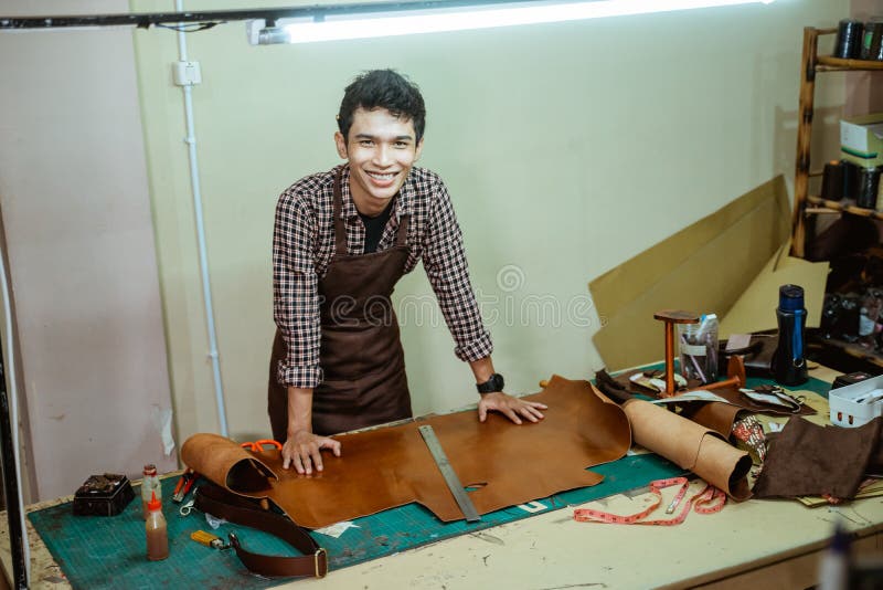 Young Asian Man Smiling at Work Making Patterns from Leather Stock ...
