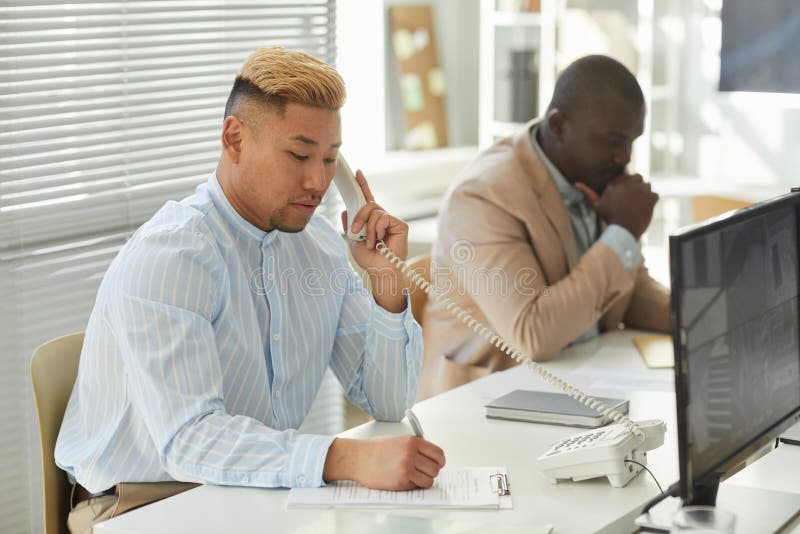 Young Asian Man Speaking by Phone in Customer Support Center Stock ...
