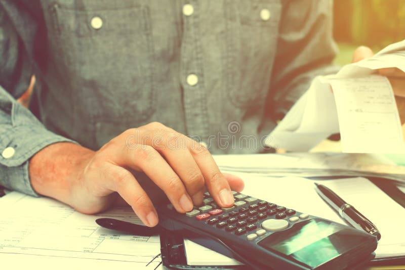 Young Asian Man Using Calculator and Calculating Bills in Home. Stock ...