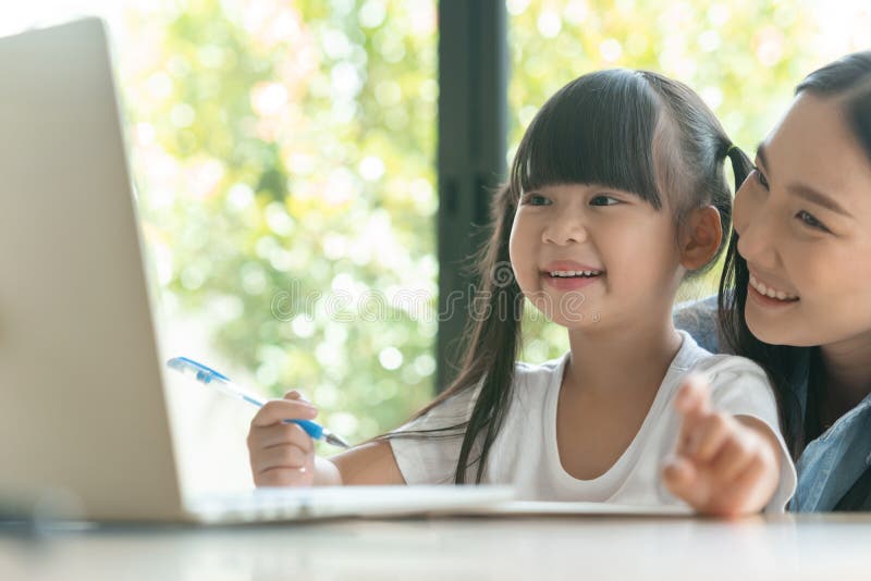 Young Asian Mother On Blue Shirt Enjoy Teaching Her Adorable Daughter A