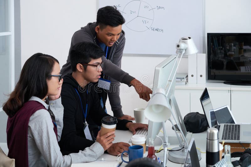 Asian Programmers Man are Relaxing and Looking at the Code on the ... Asian Programmers Man are Relaxing and Looking at the Code on the ...