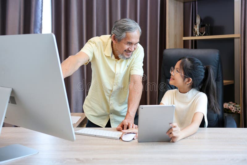 Young Asian Schoolgirl is Doing Her Class Homework Assignment at Home with Advice from ...