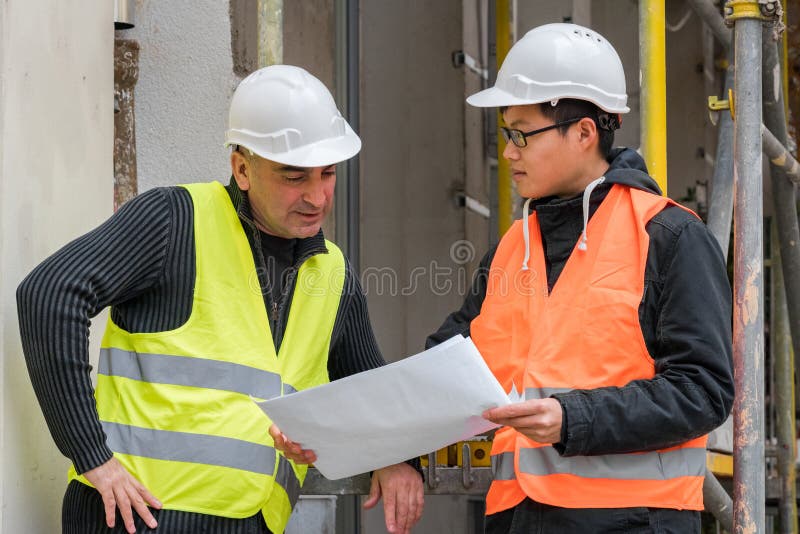 Asian Apprentice Engineer at Work on Construction Site with the Senior ...