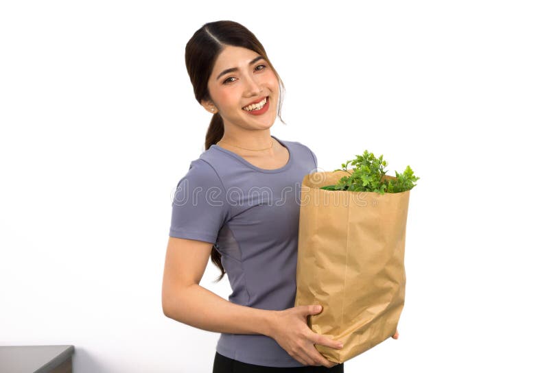 Young Asian Woman In Casual Wear Stand With A Smile Holding Paper Bag