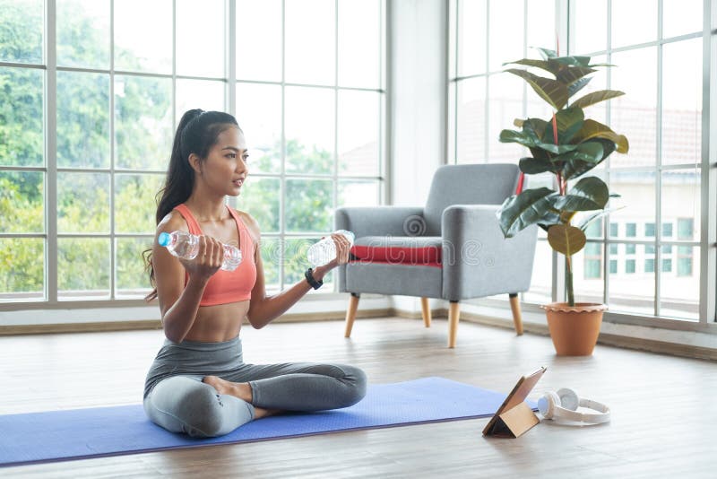 Young Asian Woman Doing Exercises with Water Bottle As Dumbbell while ...
