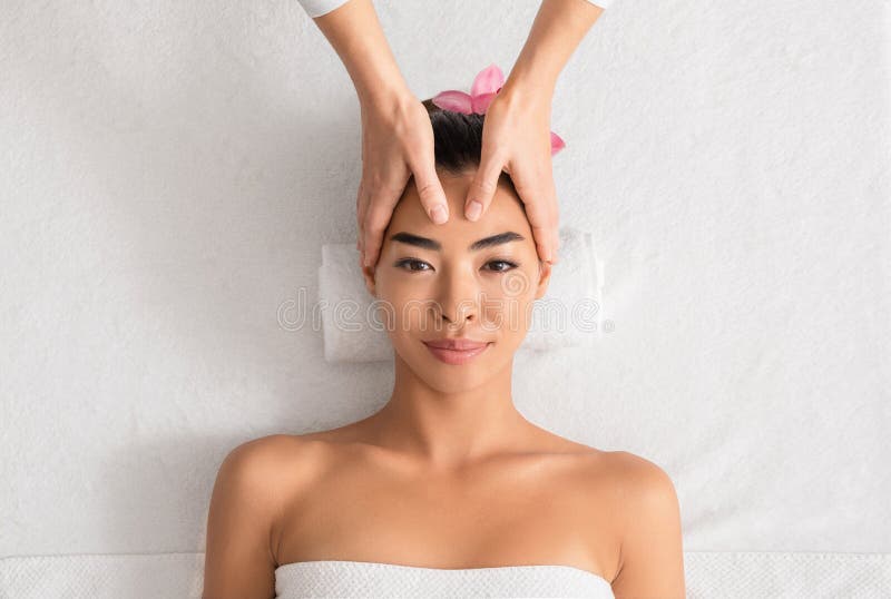 Young Asian Woman Enjoying Anti Aging Facial Massage At Spa Salon Stock