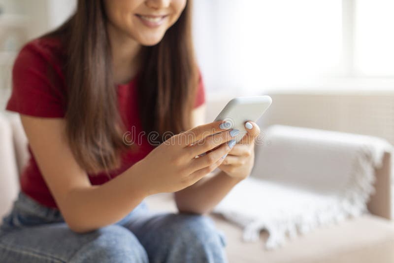 Young Asian Woman Focused On Her Smartphone Sitting On Couch At Home Stock Image Image Of