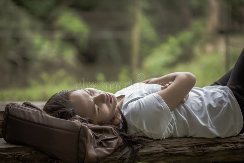 Young Asian Woman Lay Down on Backpack and Sleeping on Wood Bench in ...