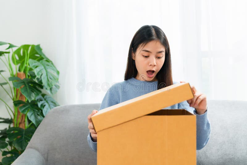 Young Asian Woman Open Box Parcel while Sitting on Sofa. Stock Image ...