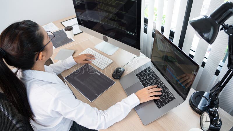 Young Asian Woman Programmer Typing Code Working With Computer At Table Coding Cyberspace And