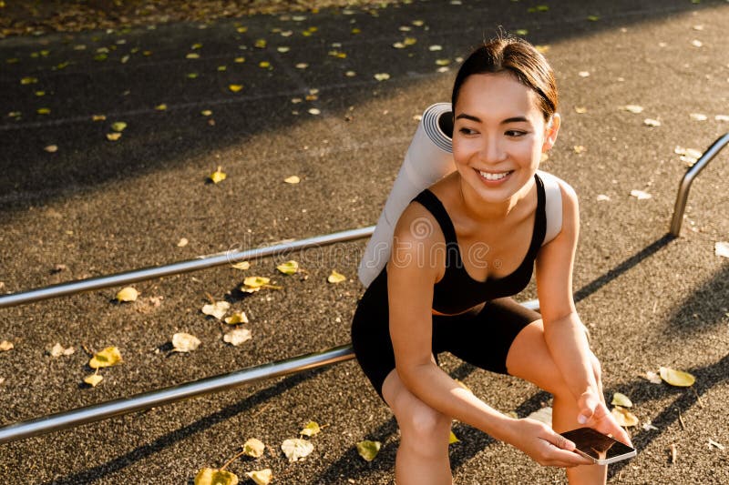 Young Asian Woman Using Cellphone after Workout on Playground Stock ...