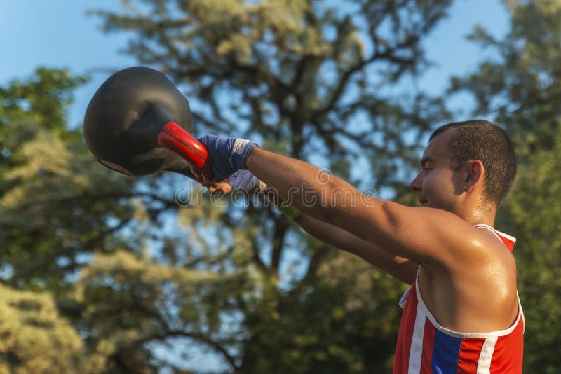 Young Athlete Doing Exercises with a Sporting Projectile of Kettlebells ...