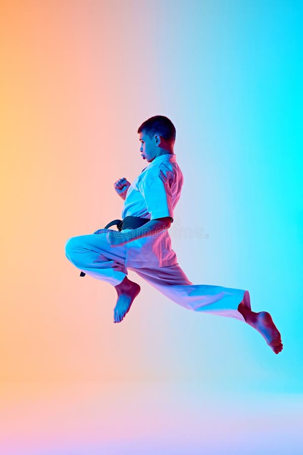 Young Athlete Engaged in Karate Training, Jumping in Dynamic Pose ...