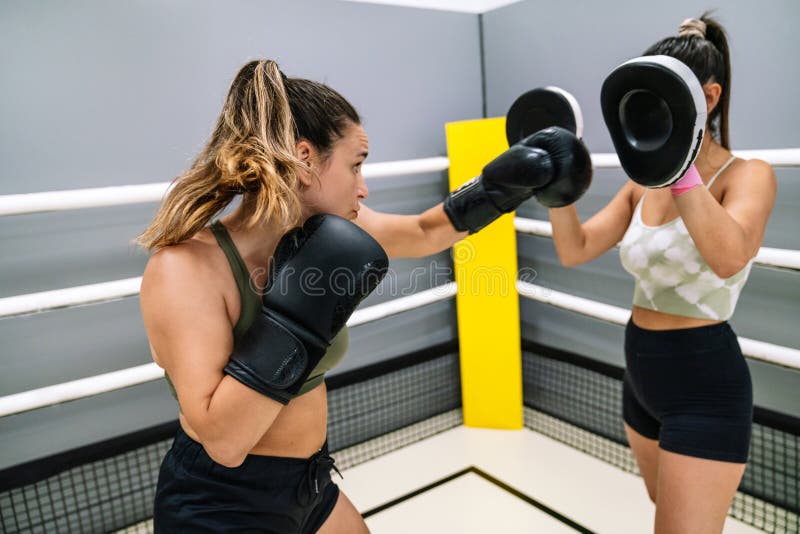 Young Athlete Practicing Boxing Punches in Pair with Instructor Inside ...