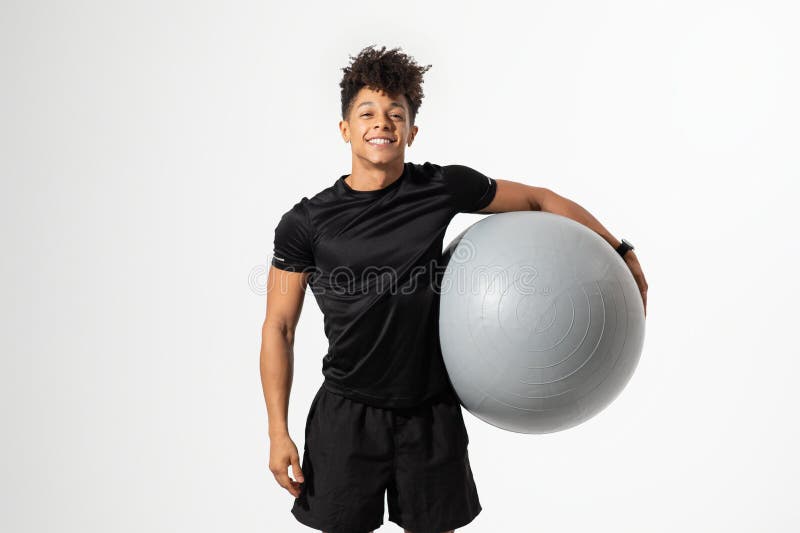 Young Athlete Smiling while Holding Large Exercise Ball in Studio Stock ...
