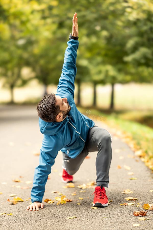 A Young Athlete is Warming Up before Running Training in the Park Stock ...