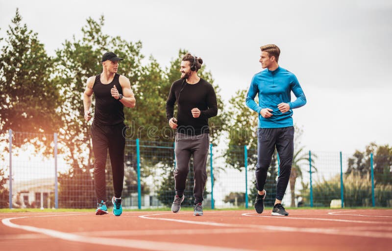 Athletes Practicing a Run on Athletics Stadium Track. Stock Image ...