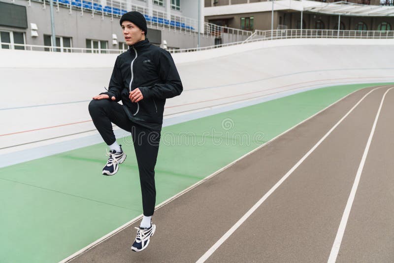 Young Athletic Runner Man Jumping while Warming Up at Stadium Stock ...