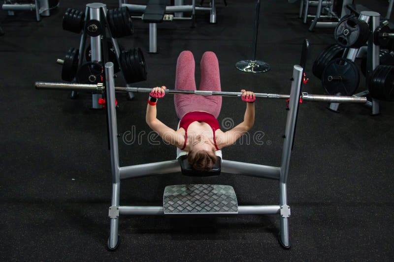 Athletic Woman Doing Barbell Bench Press on a Bench in the Gym Stock ...
