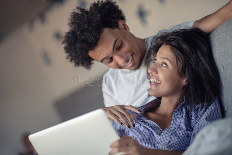 Young Attractive Diverse Couple Browsing Internet, Using Laptop ...