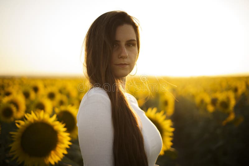 Young and Attractive Female Standing among Full Bloom Sunflower Fields ...