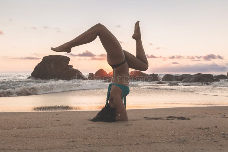 Young Attractive Latin Woman Wearing A Bikini Practicing Yoga On The