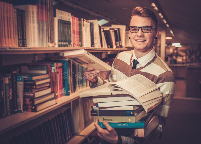 Young Attractive Librarian Holding a Pile of Books in the University ...