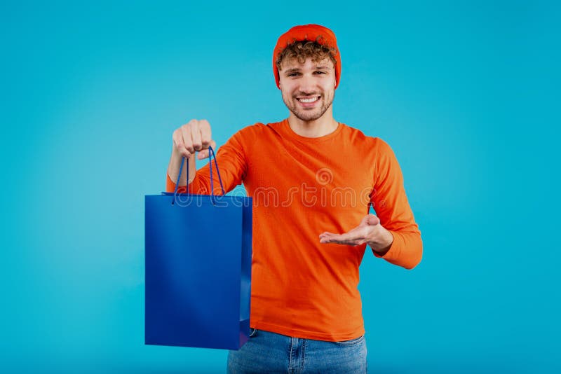 Young Attractive Man Holds Shopping Bag Looking Happy and Satisfied on ... Young Attractive Man Holds Shopping Bag Looking Happy and Satisfied on ...