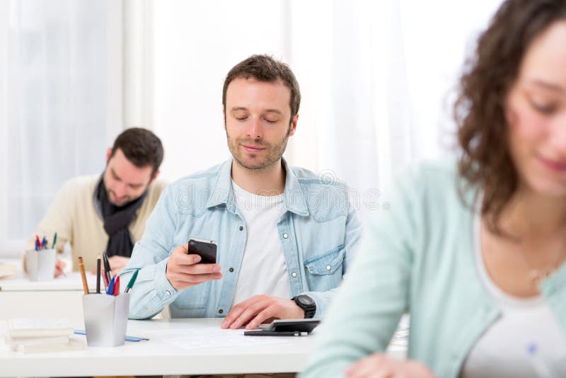 Young Attractive Student Using His Mobile during Classes Stock Image ...