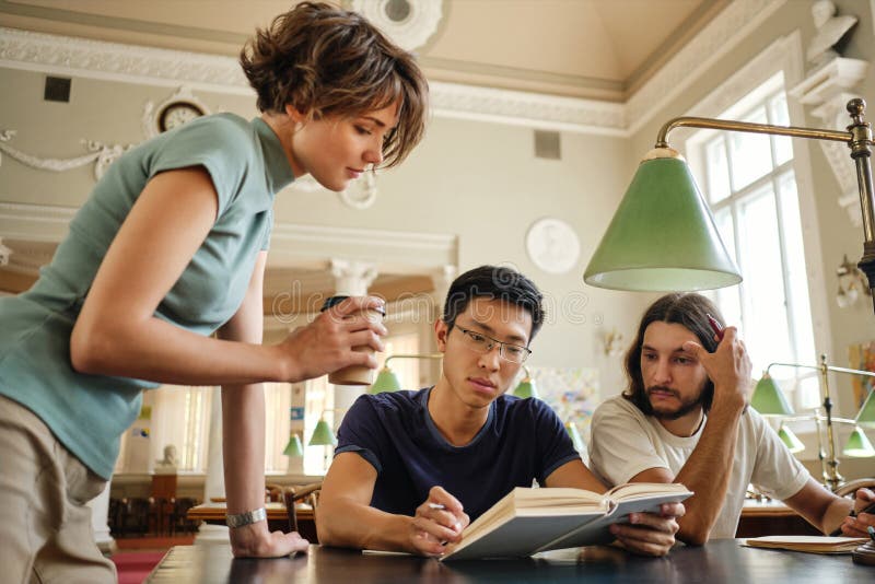 Young Attractive Tutor Helping Multinational Students with Study during ...