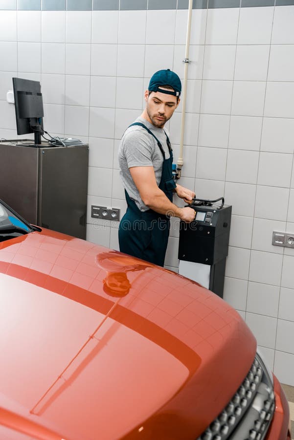Young Auto Mechanic in Uniform Looking at New Automobile Stock Photo ...