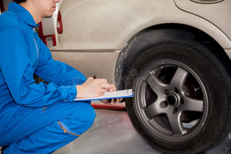 Young Automotive Technician Checking on Car Tires in Garage Stock Photo ...