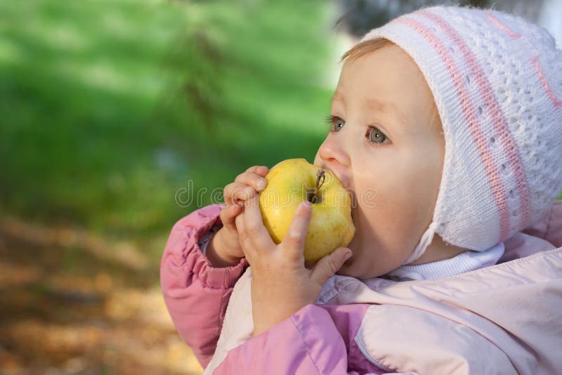 Young Baby Eating a Yellow Apple Stock Image - Image of hand, baby ...