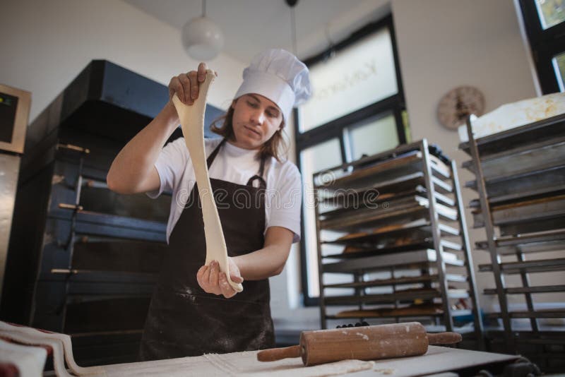 Young Baker with Chef Cap Preparing Pastries in Bakery. Stock Photo ...