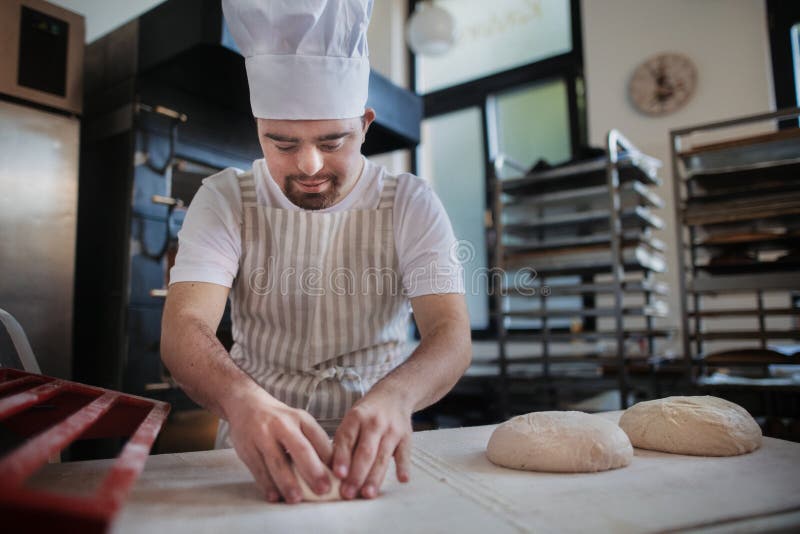 Young Baker with Down Syndrome Preparing Pastries in Bakery. Concept of ...